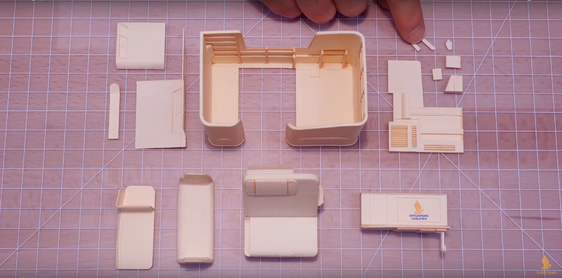 Artist takes paper planes to the next level, builds tiny seats complete ...