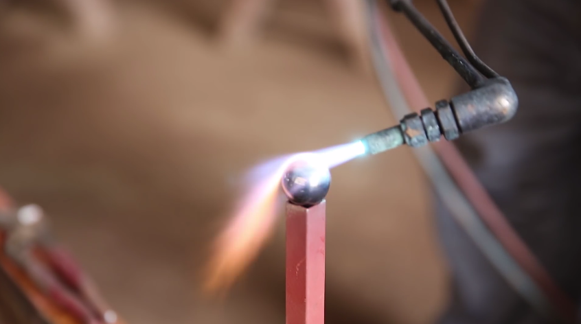 Watch a super hot ball of iron get dropped onto an ice cube, because ...